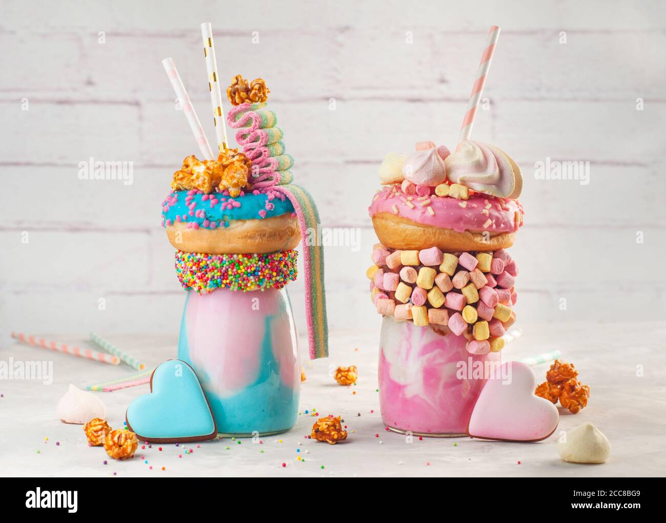 Two freak shakes topping with donut, marshmallow, popcorn and marmalade ...