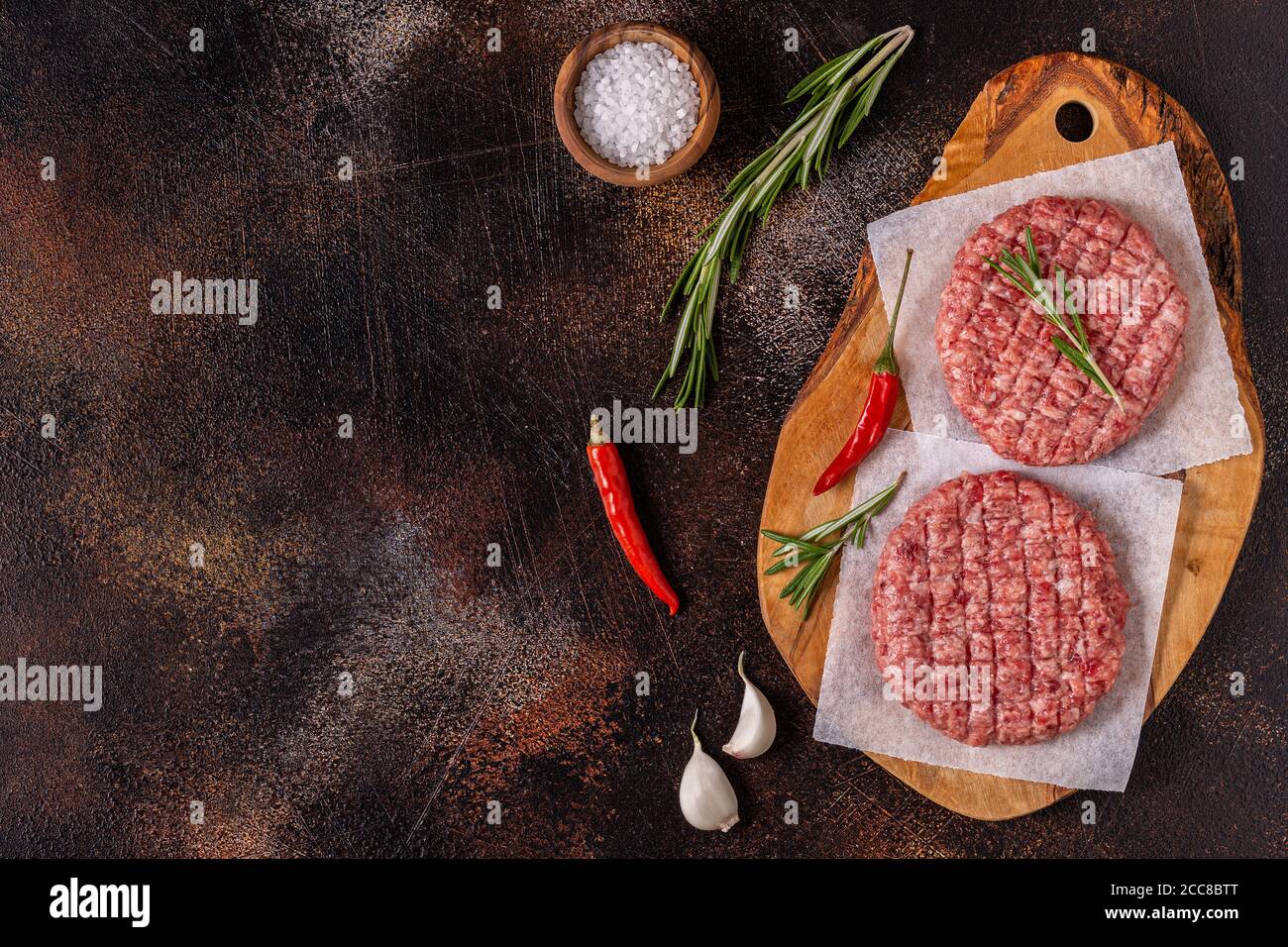 Fresh raw minced homemade grill beef burgers on wooden chopping board ...