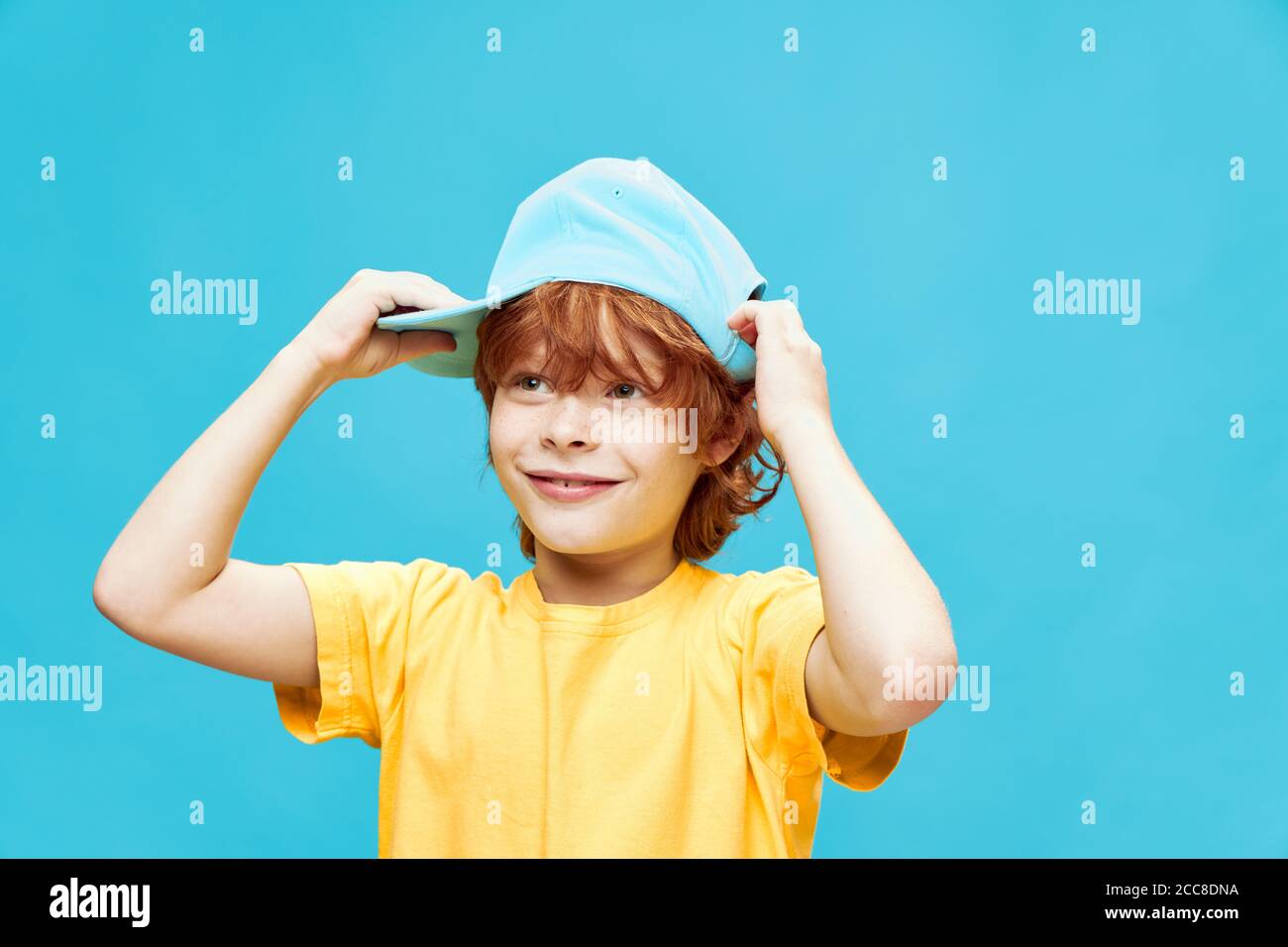 Red-haired boy with a cap on his head and in a yellow T-shirt Stock ...