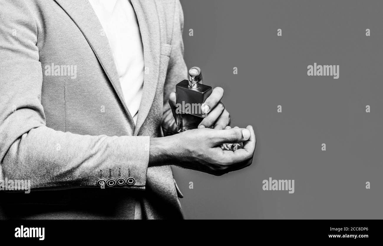 Man holding up bottle of perfume. Men perfume in the hand on suit ...