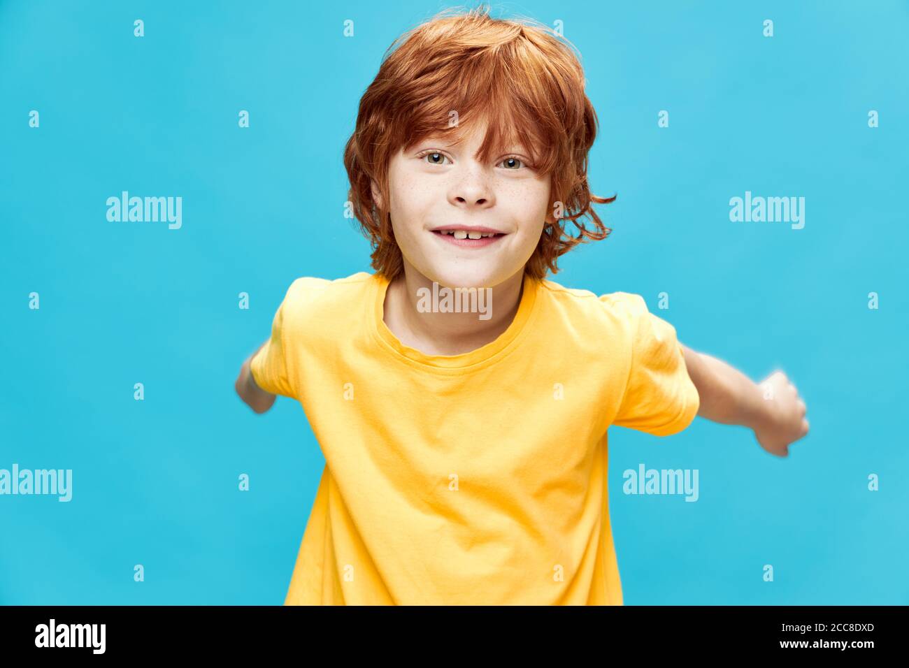 Red-haired child smiles and holds hands behind his back Stock Photo - Alamy