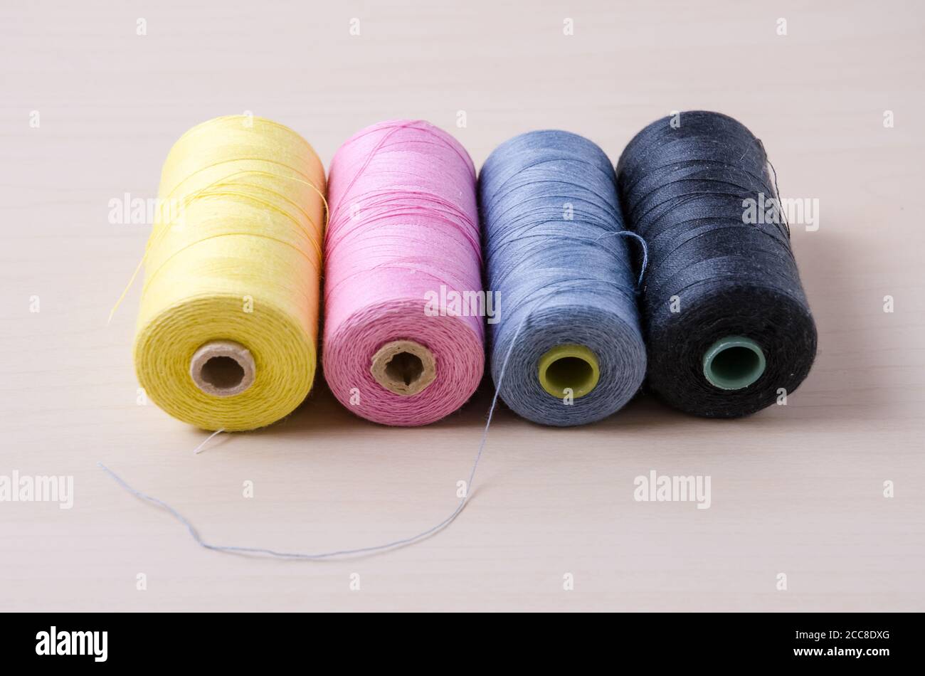Flat lay of spools with colorful threads on wooden desk or table, home ...