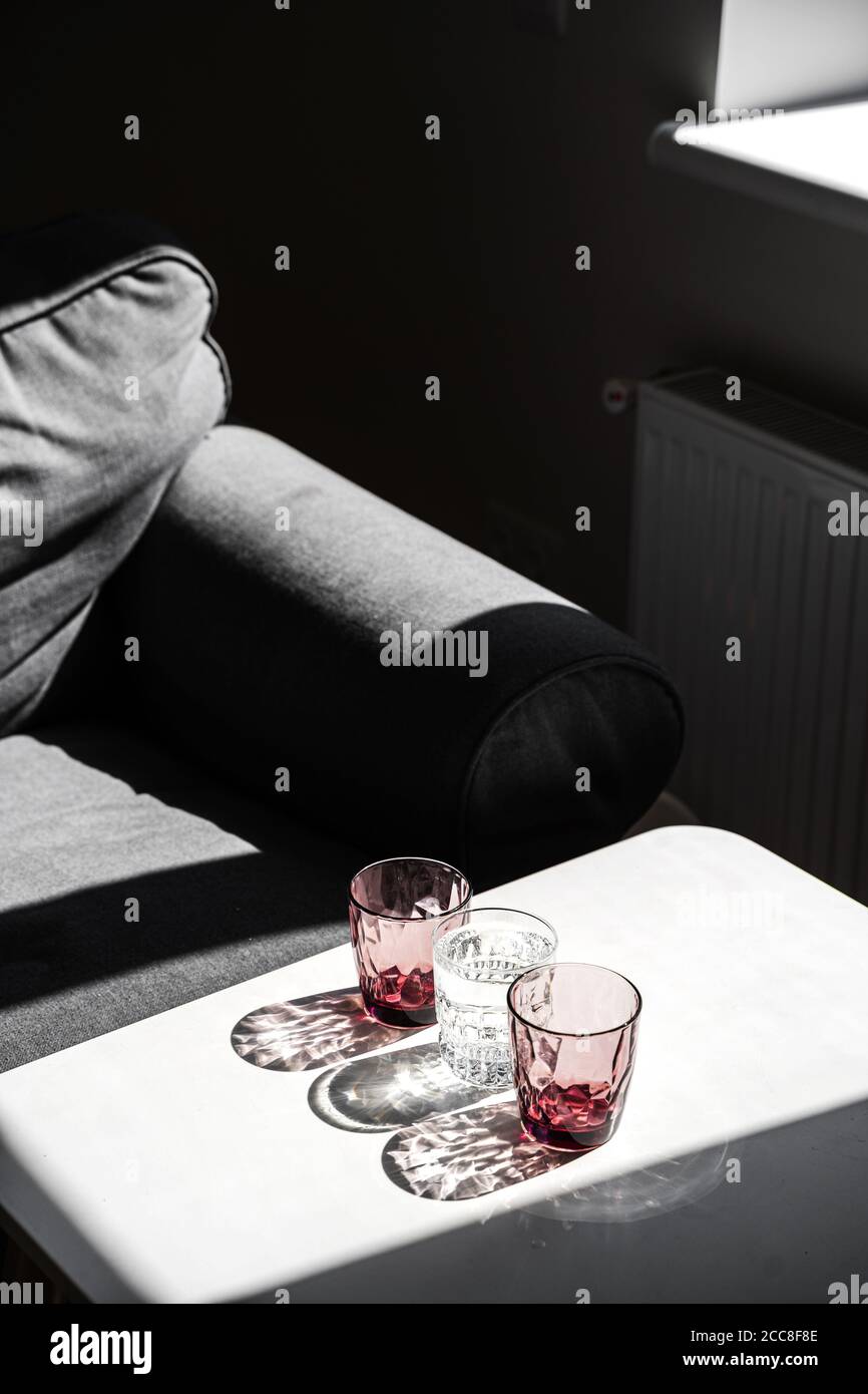 Crystal red glass on white table. Hard shadows in sunlight Stock Photo ...