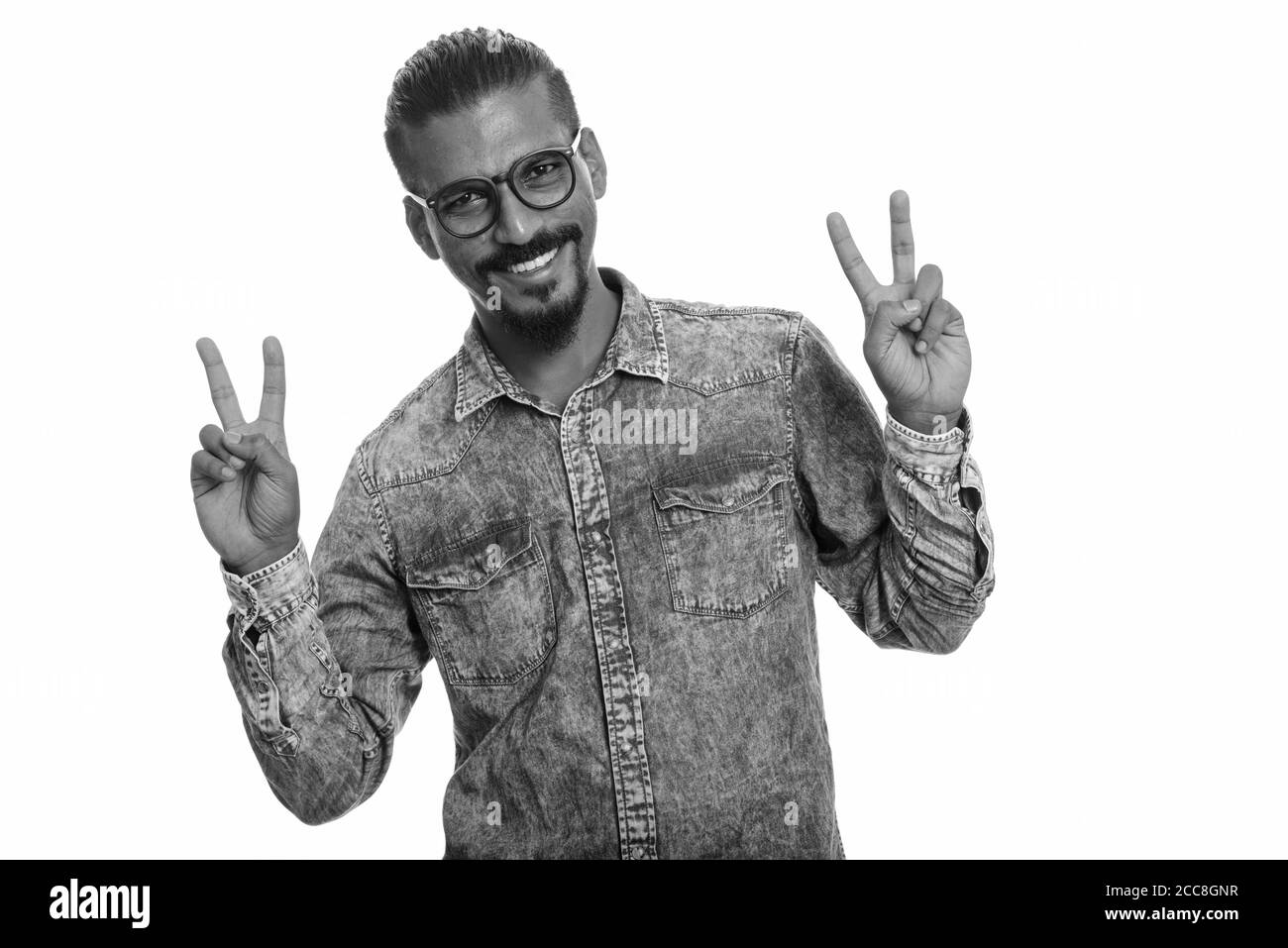Young happy Indian man giving peace sign Stock Photo - Alamy