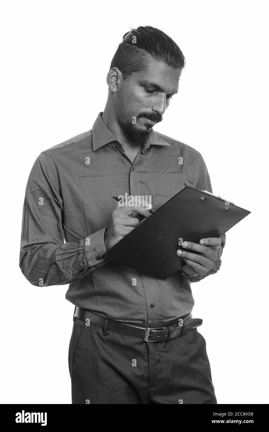 Young Indian businessman writing report on clipboard Stock Photo - Alamy