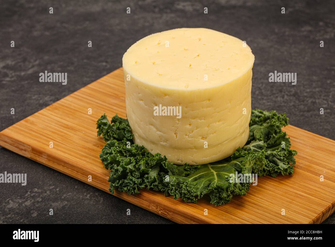 Yellow round dairy soft cheese piece Stock Photo - Alamy