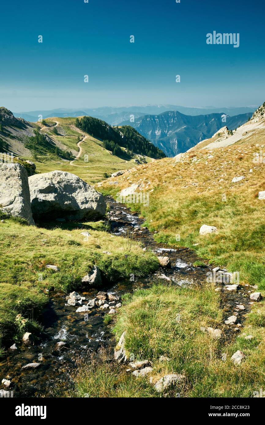 Majestic mountainous landscape with narrow waterway flowing from hills ...