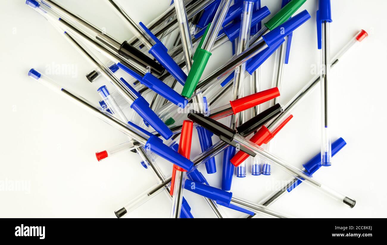 Pile of a lot multi colored plastic ballpoint pens on white background ...
