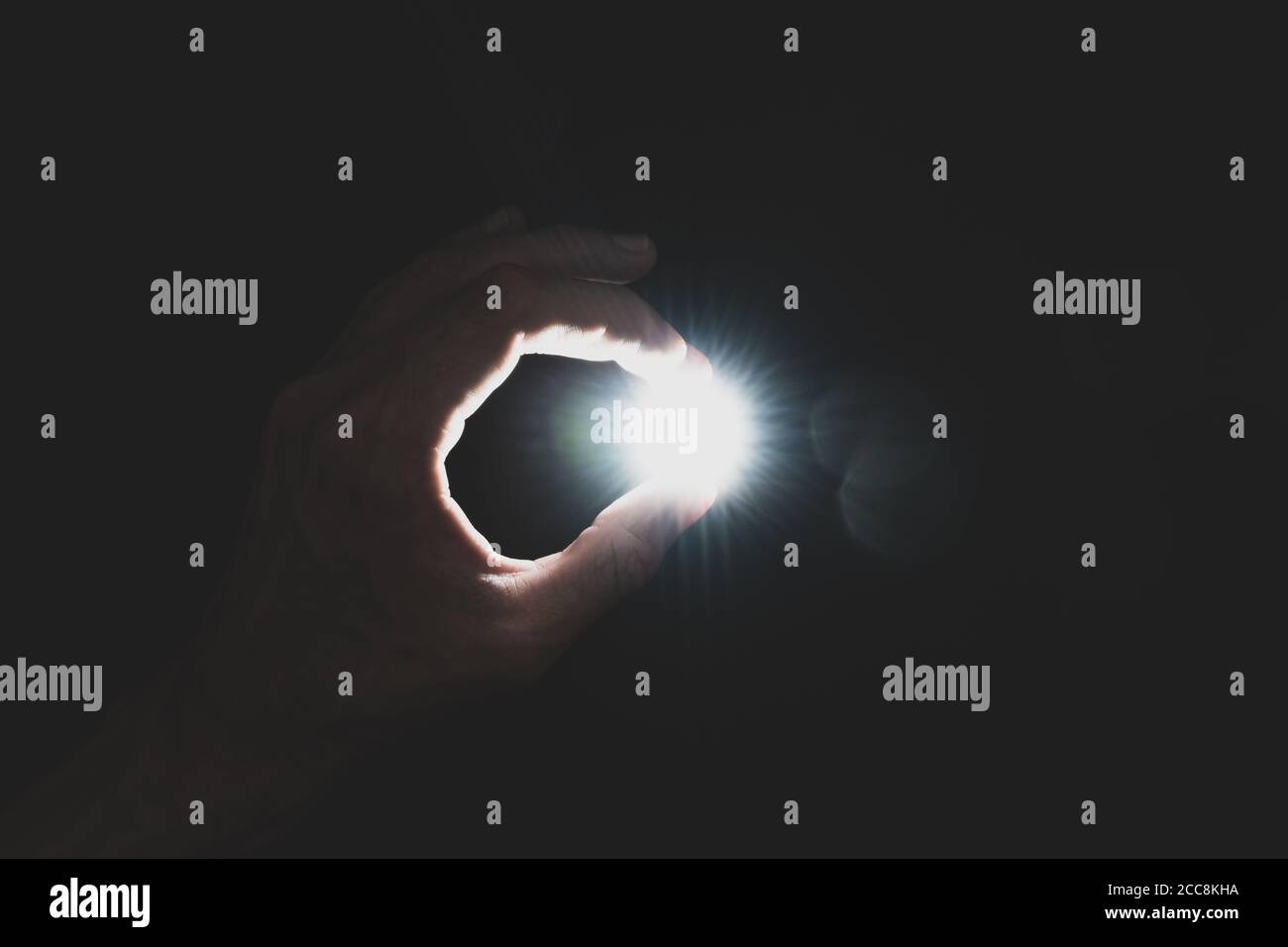 Abstract background of hand holds illuminated light or power bright ...