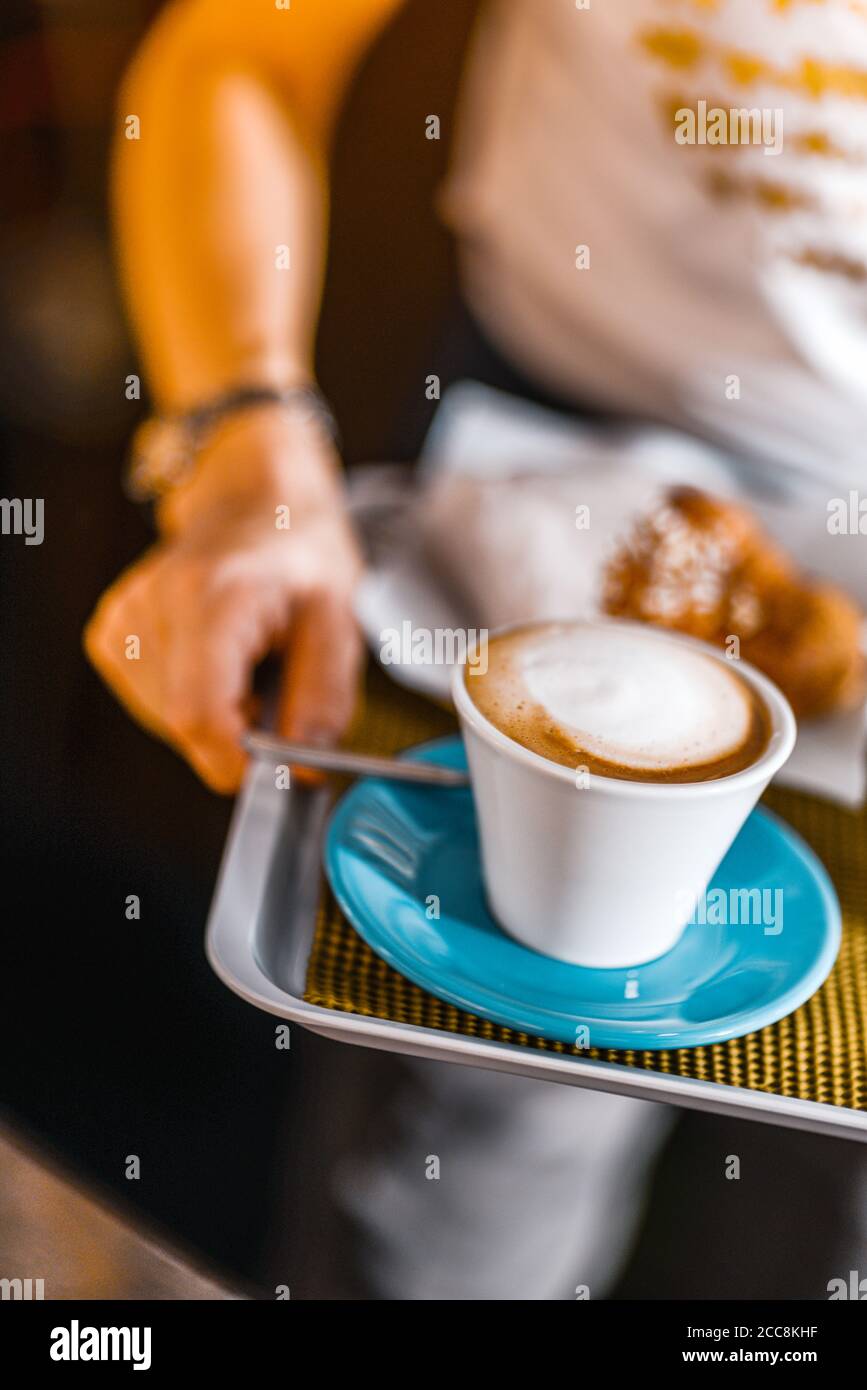 Female barista preparing and serving coffee cappuccino in a bar at ...