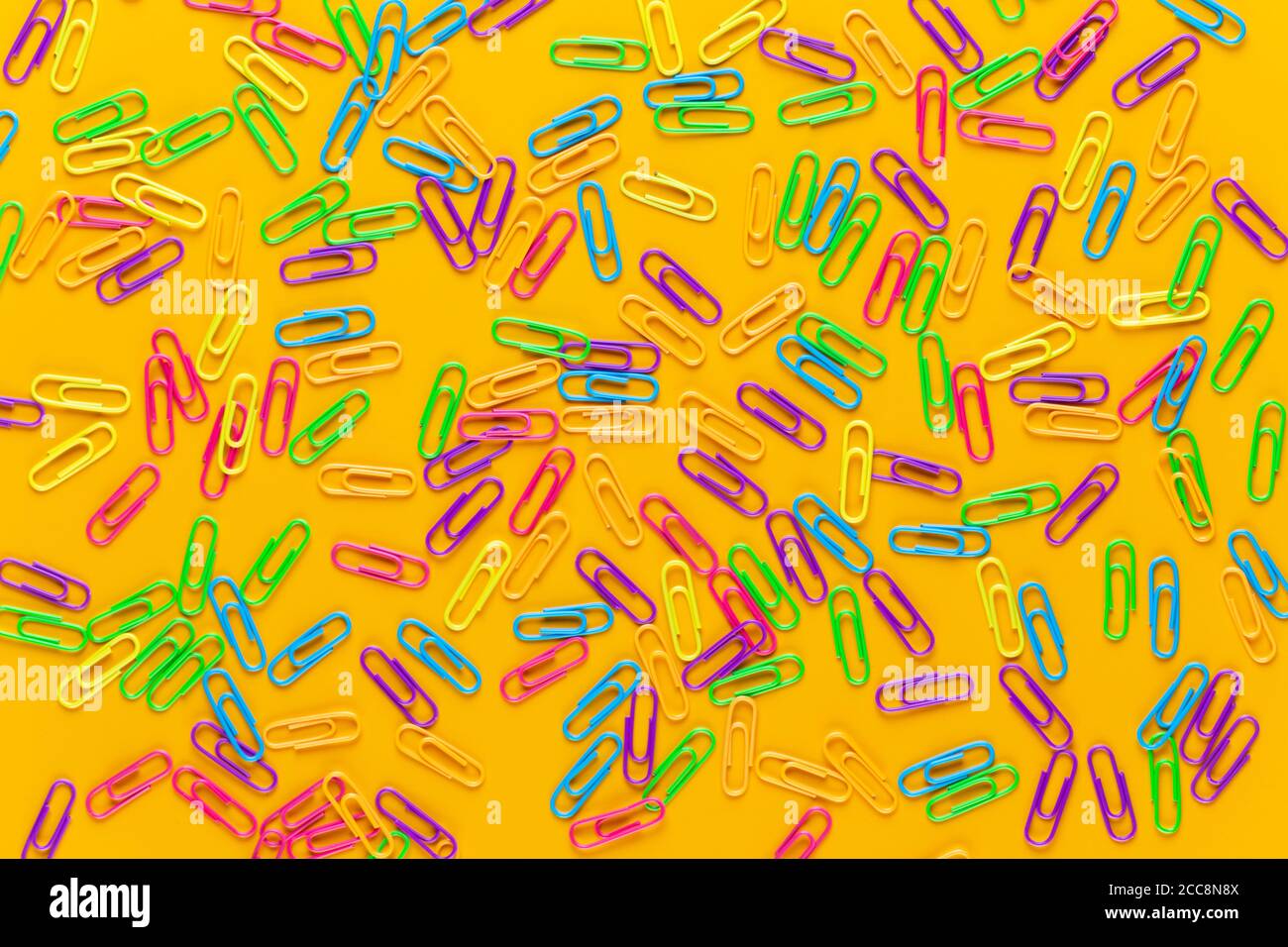 Color paper clips on yellow background, copy space. Top view, flat lay ...