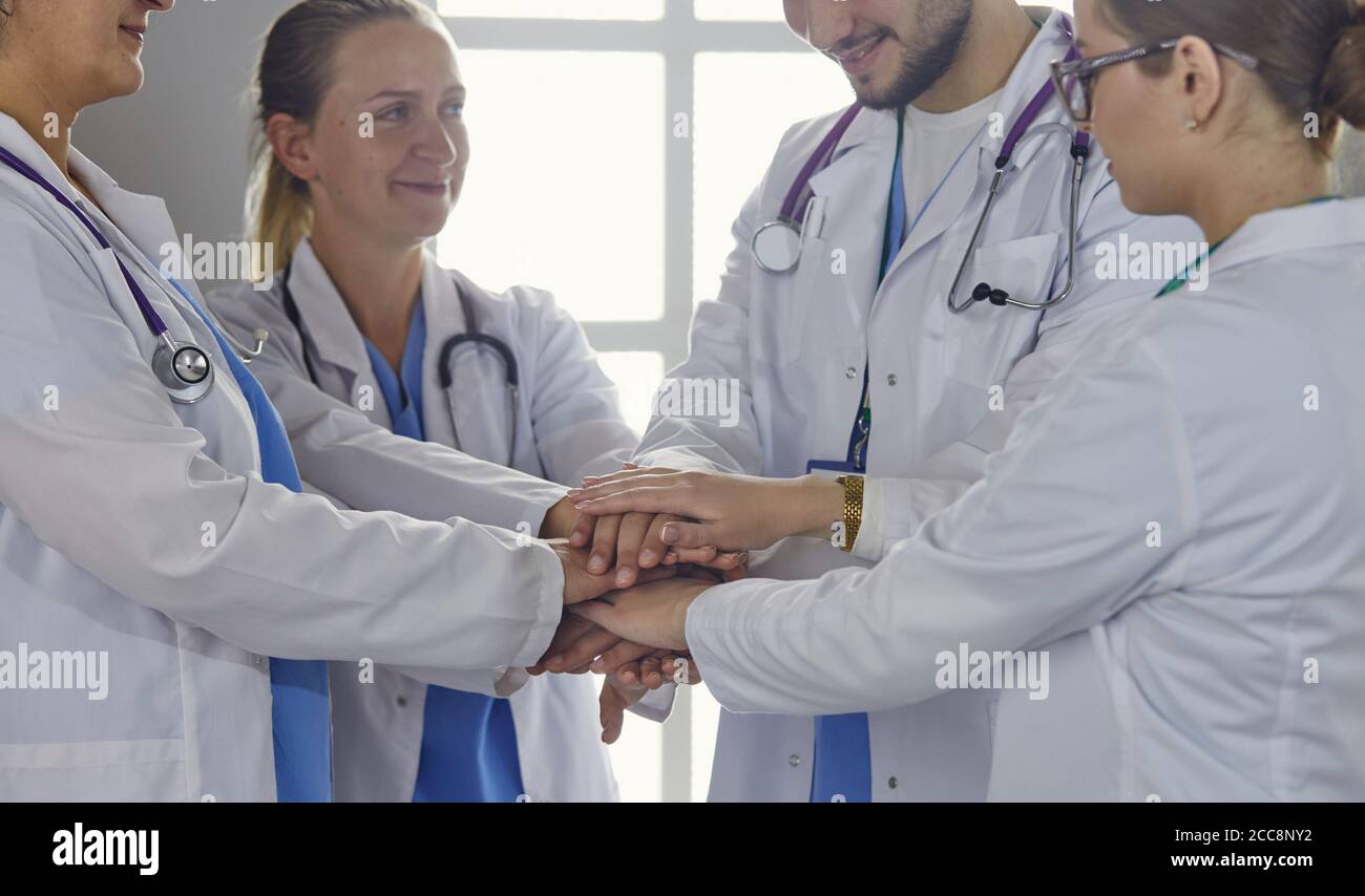 Team of medical workers holding hands together indoors, above view. Unity concept Stock Photo ...