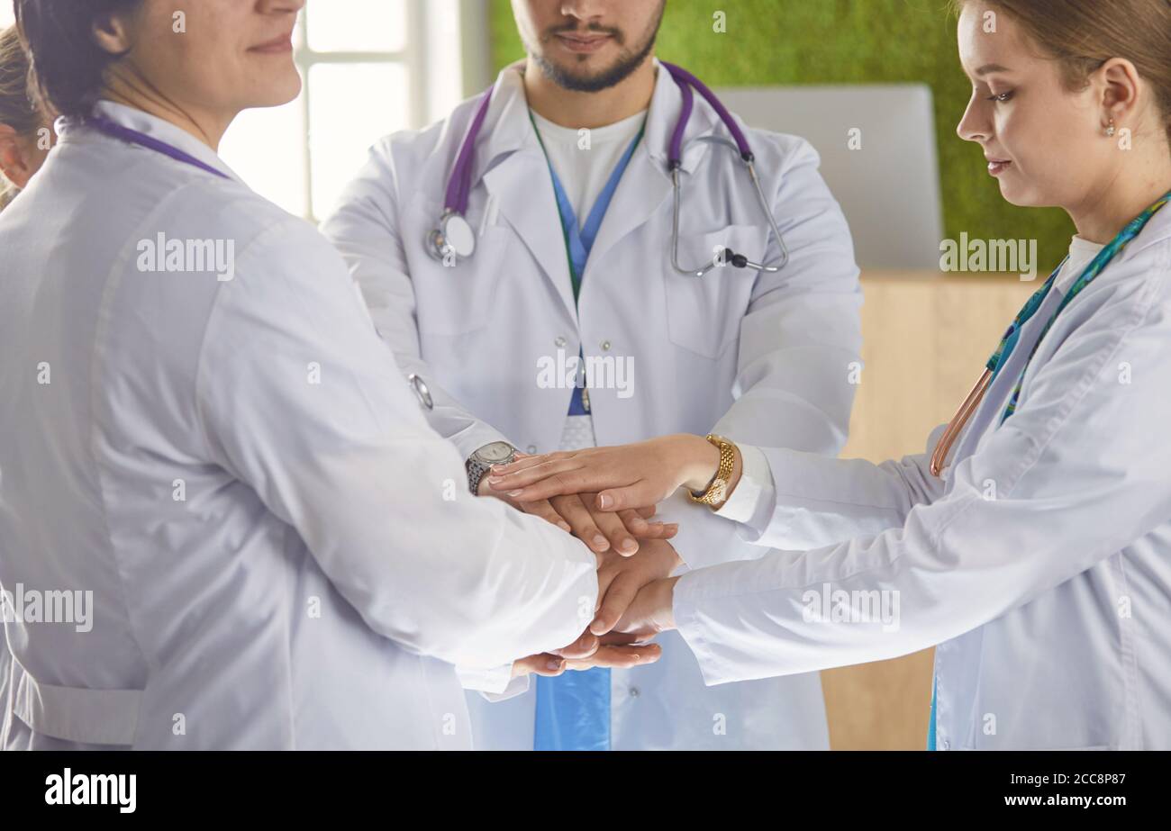 Team of medical workers holding hands together indoors, above view. Unity concept Stock Photo ...
