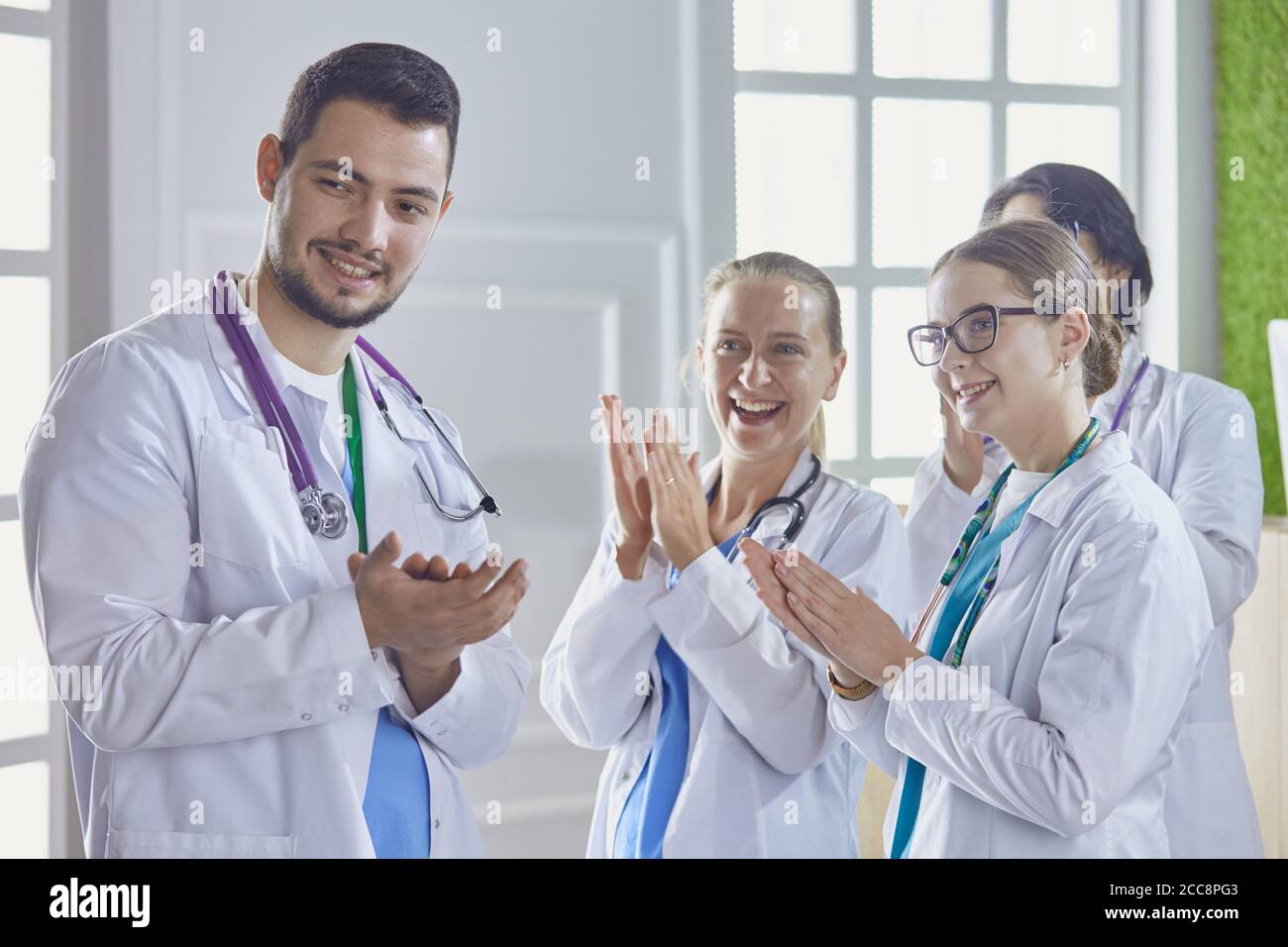 Happy medical team comprising male and female doctors smiling broadly ...