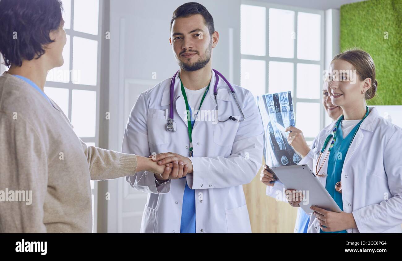 Patient with a group of doctors at the background Stock Photo - Alamy
