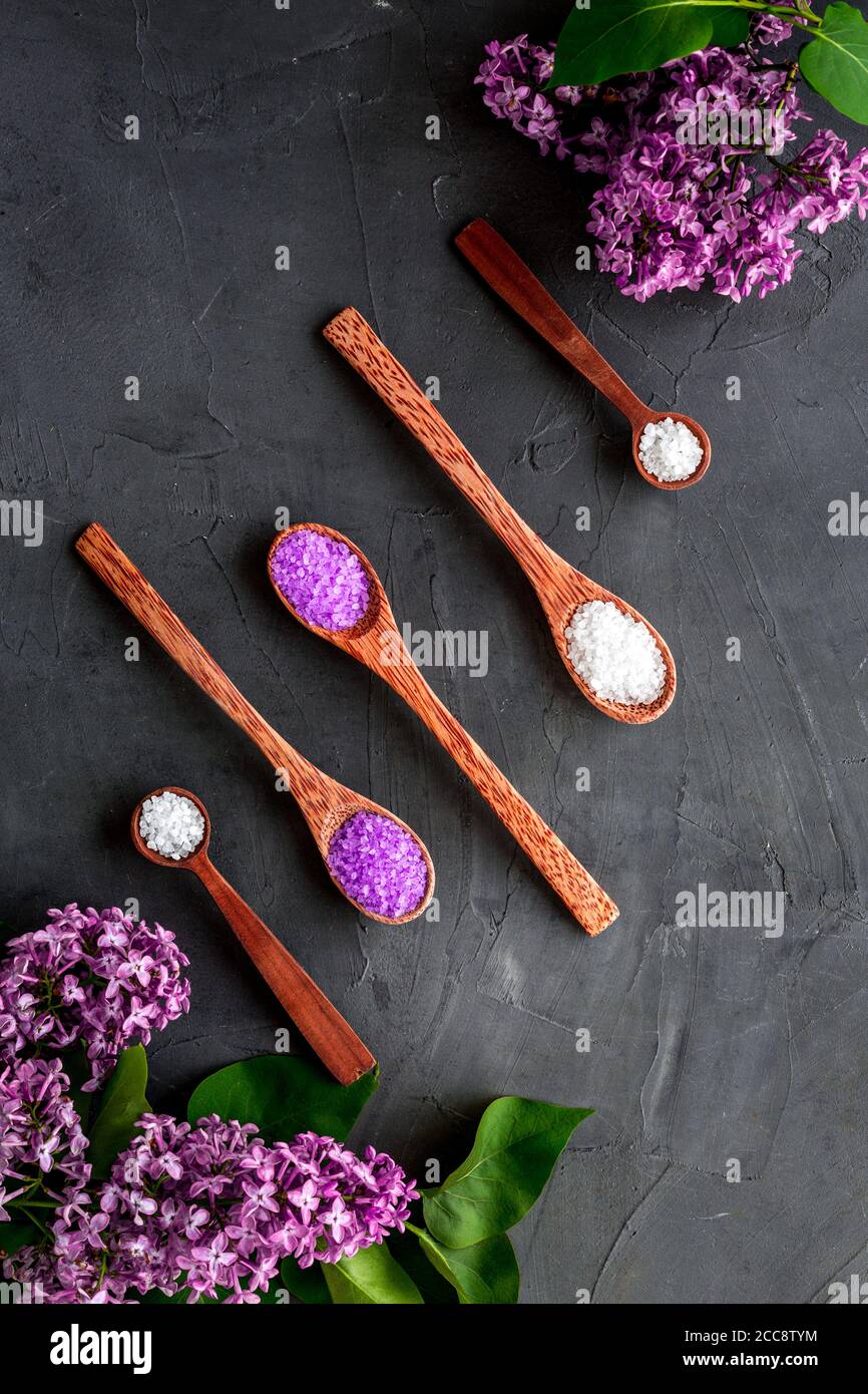 Pattern of spa sea salt in spoons with lilac flowers. Above view Stock ...
