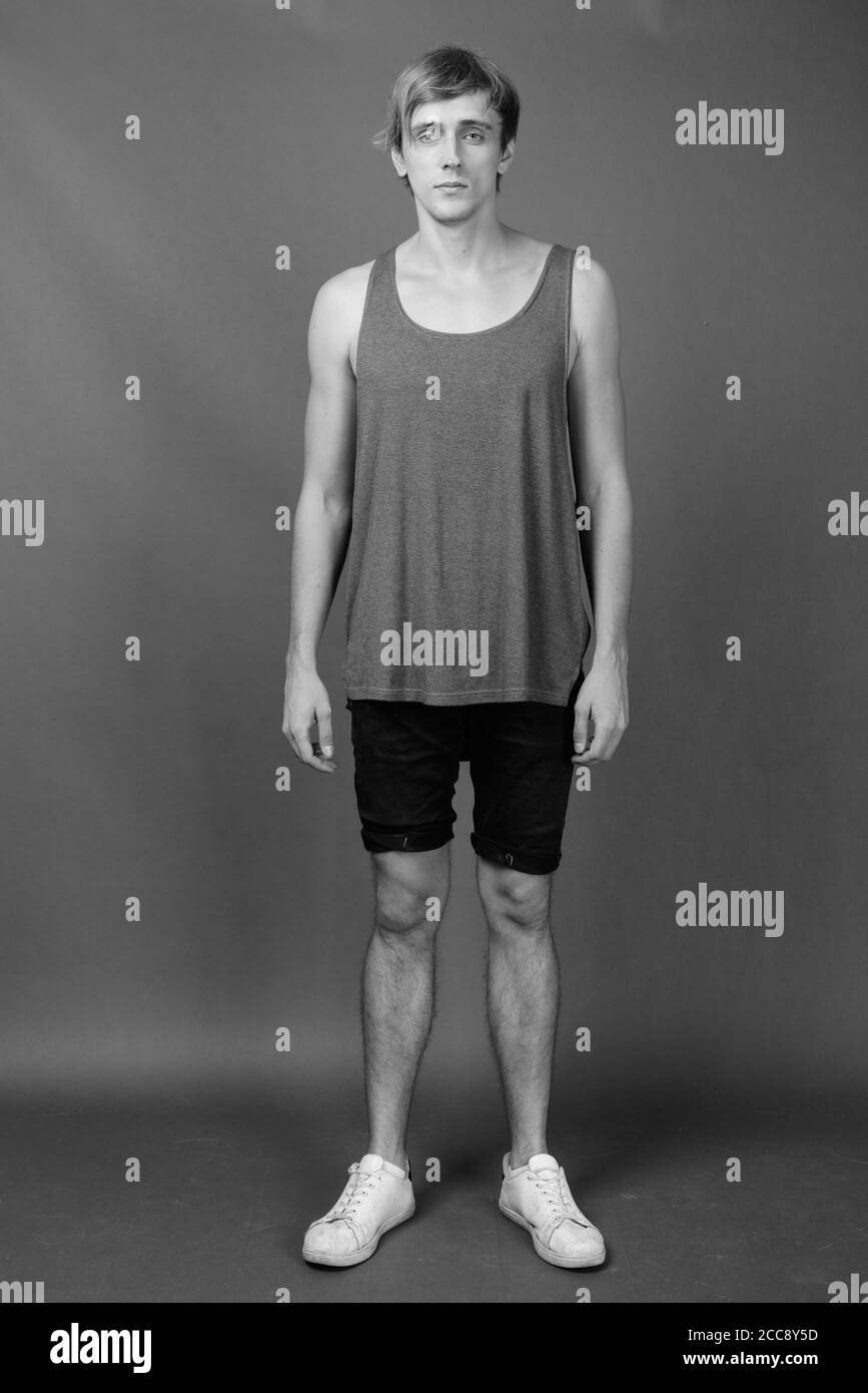 Young handsome man ready for gym against gray background Stock Photo ...