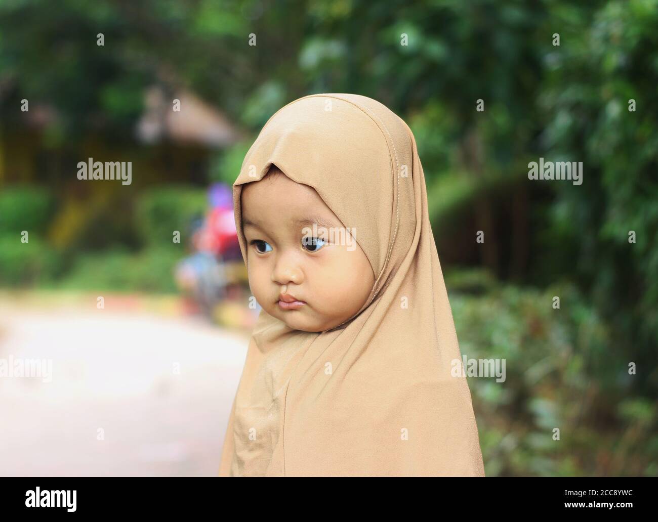A cute beautiful muslim Indonesian baby girl in the park Stock Photo ...