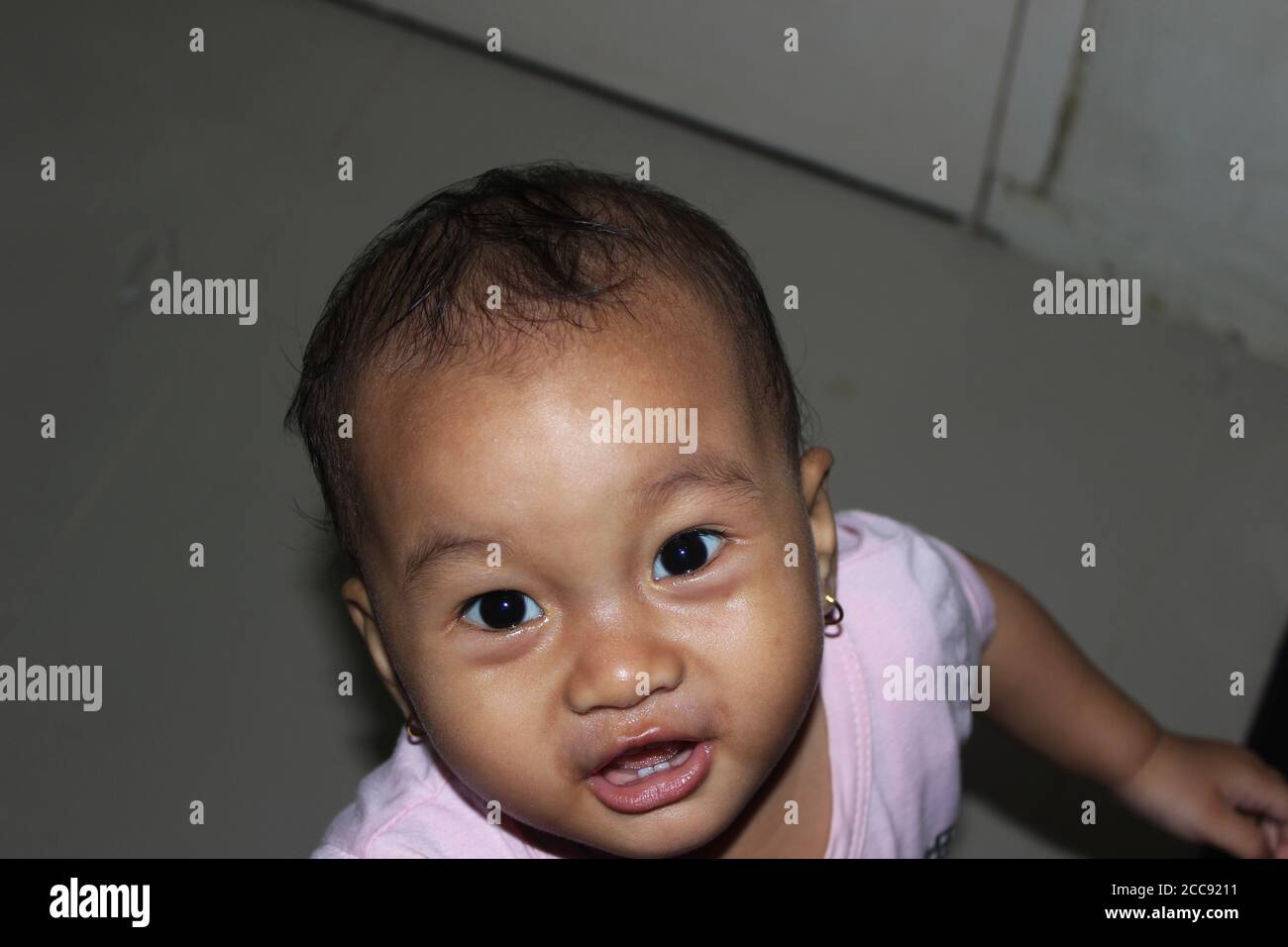 A cute beautiful Indonesian baby girl playing in the house Stock Photo ...