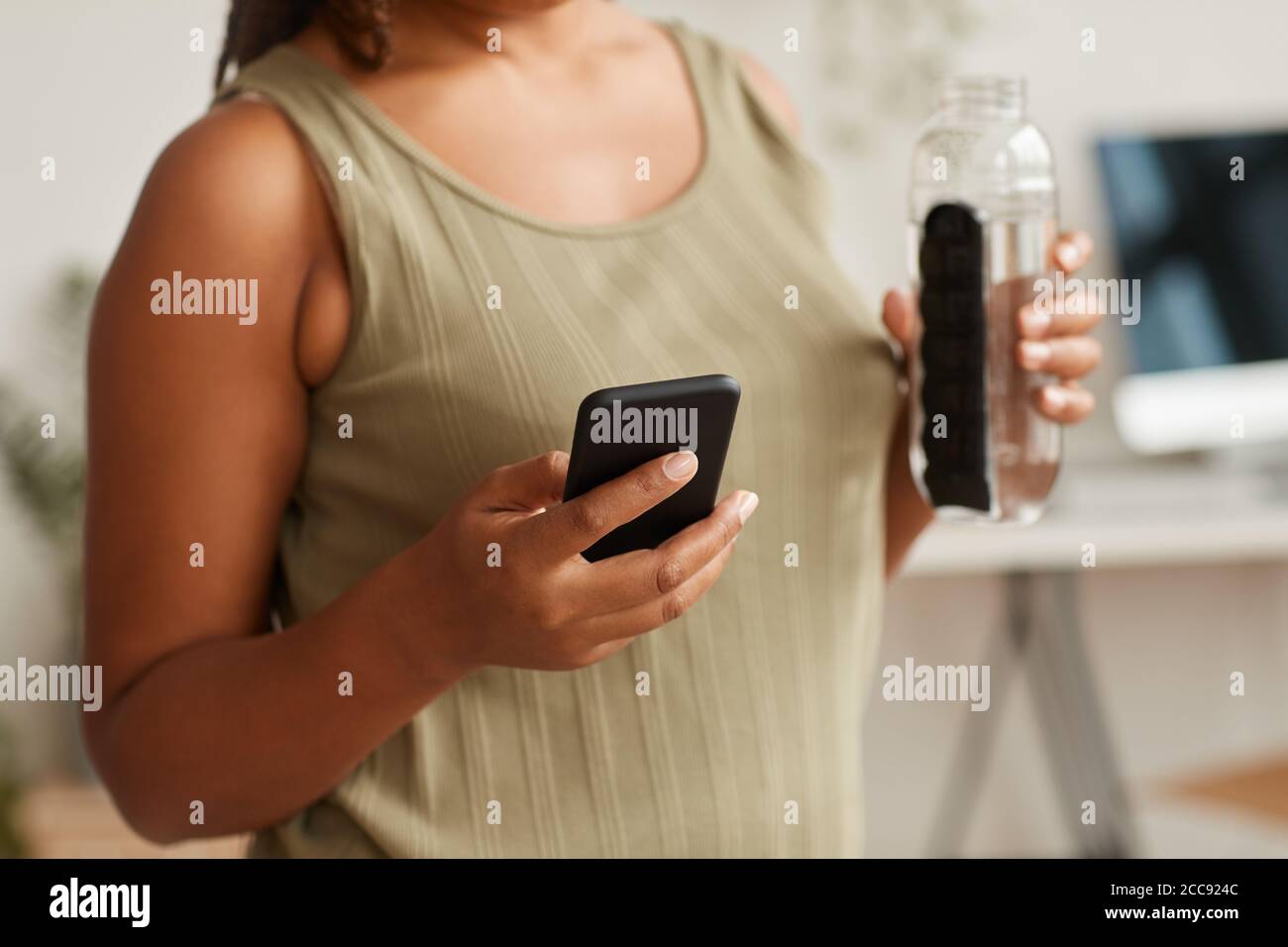 Close-up of young woman typing a message on her mobile phone while ...