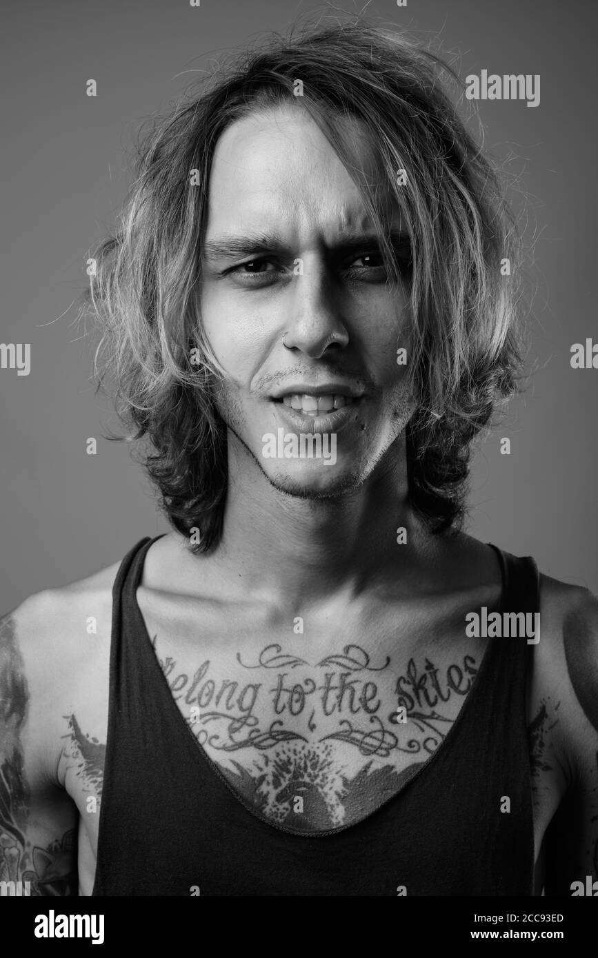 Studio shot of rebellious young man against gray background Stock Photo ...