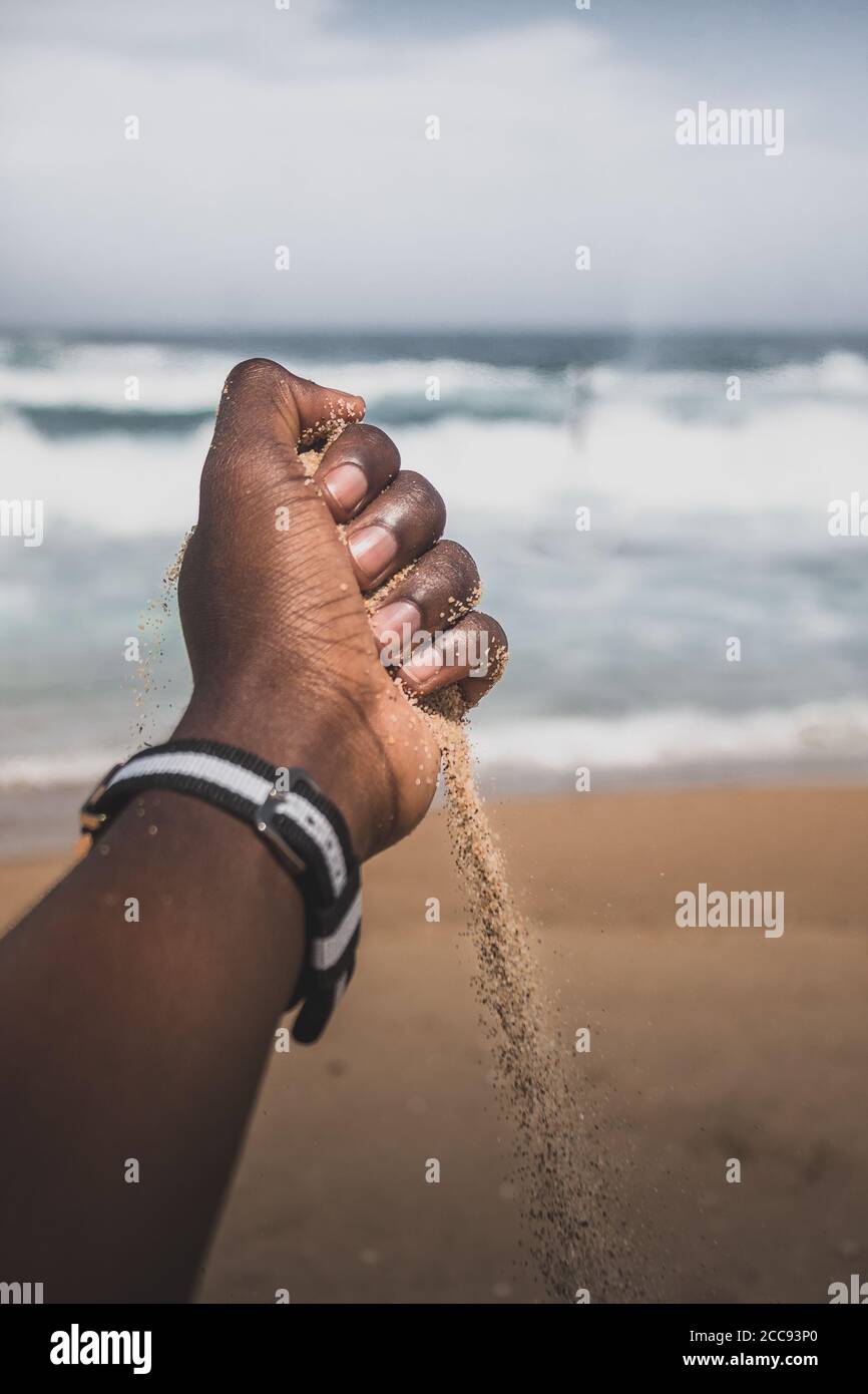 Hand pouring sand Stock Photo - Alamy