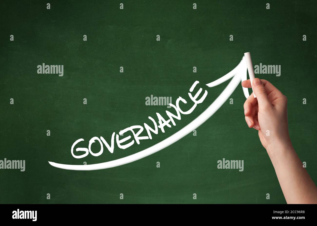Hand drawing GOVERNANCE inscription with white chalk on blackboard ...