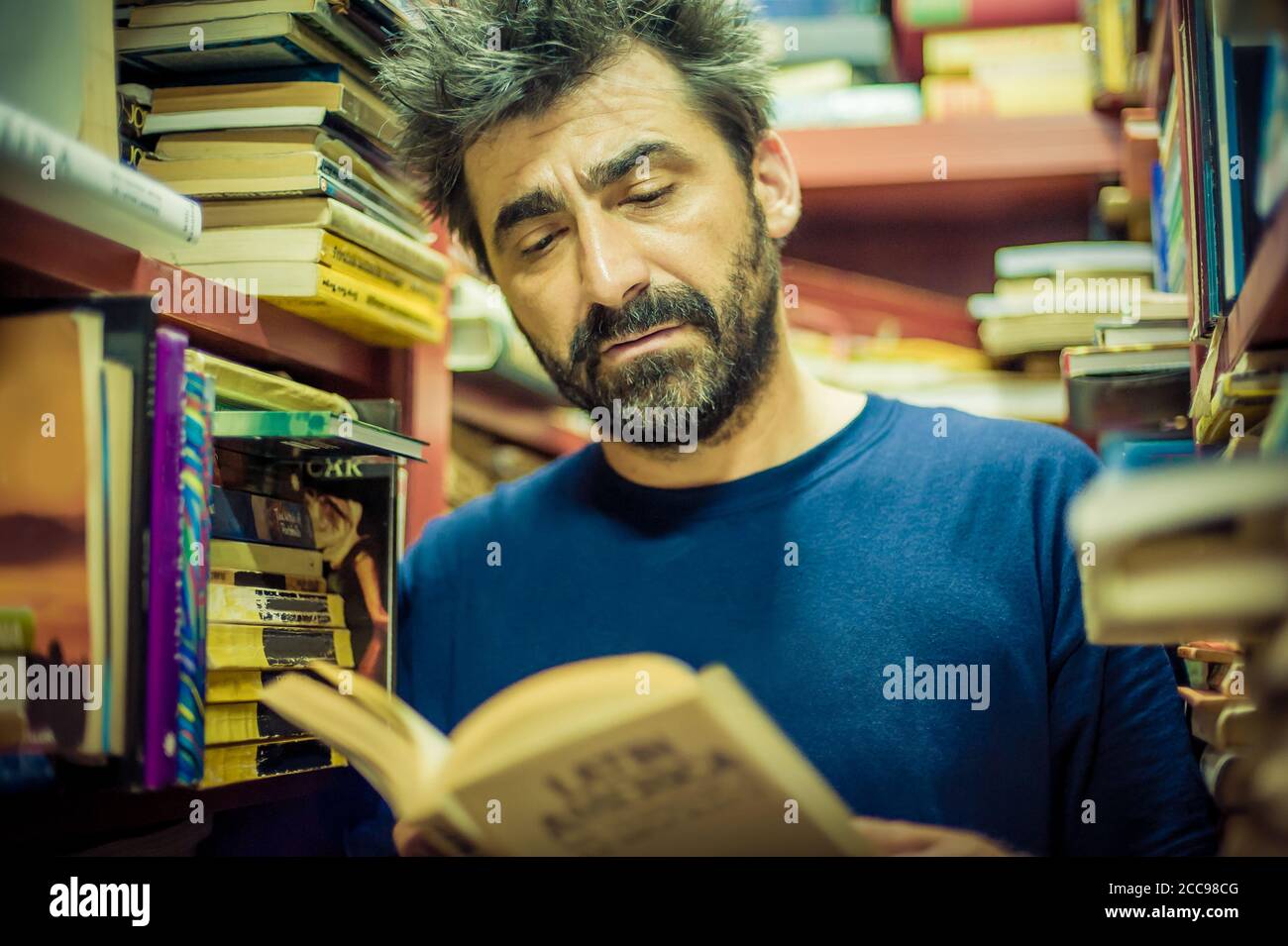 Curious man choosing book hi-res stock photography and images - Alamy