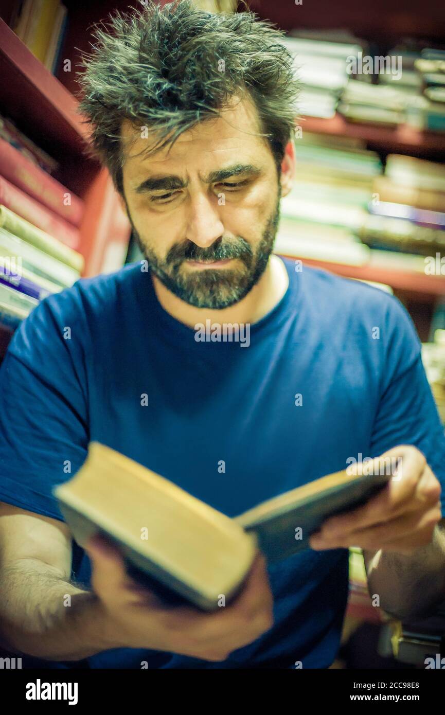 Curious man choosing book hi-res stock photography and images - Alamy