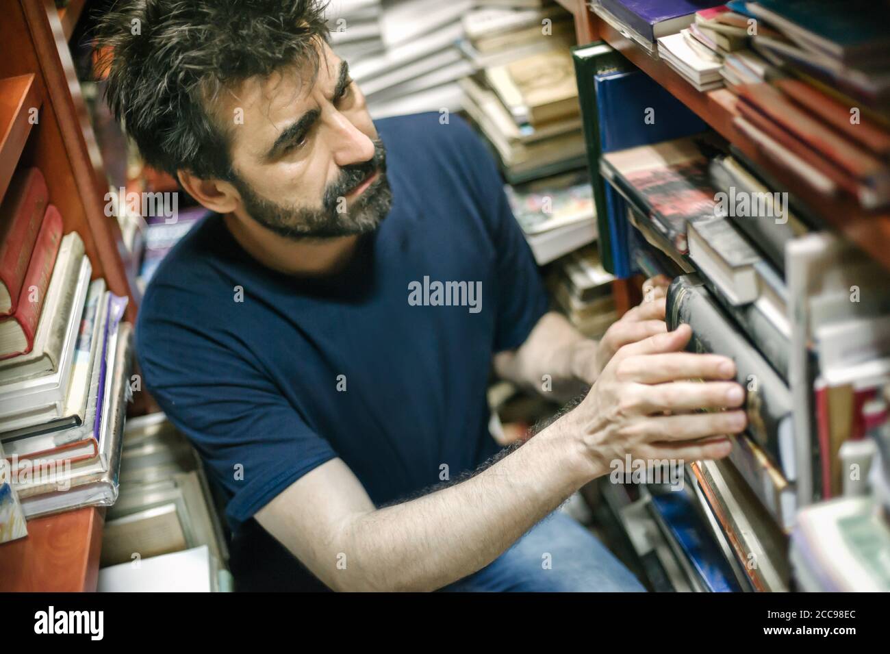 Curious man choosing book hi-res stock photography and images - Alamy