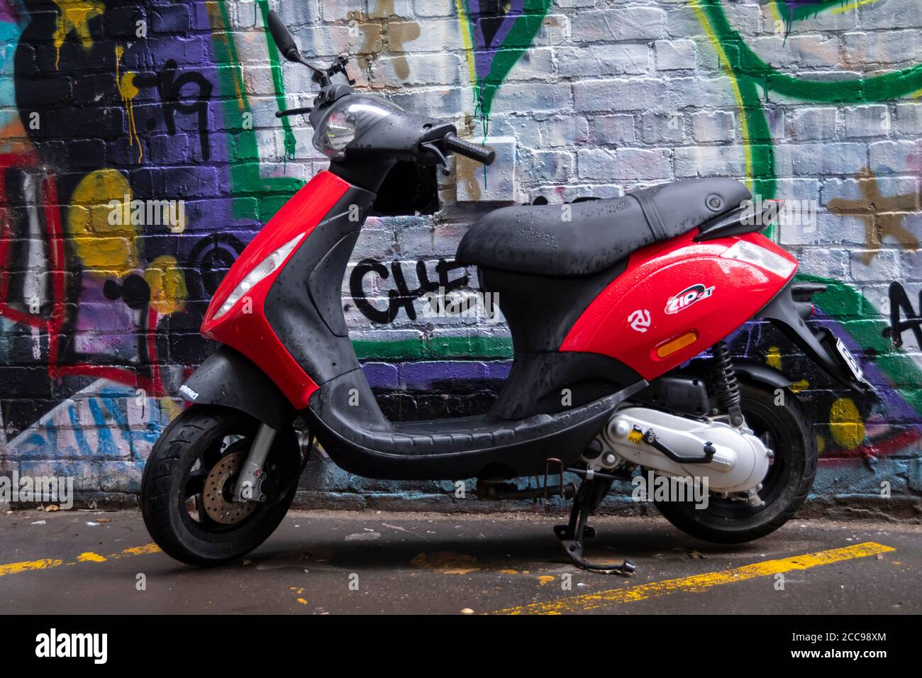 Red scooter in front of graffiti covered brick wall, Wellington, North ...