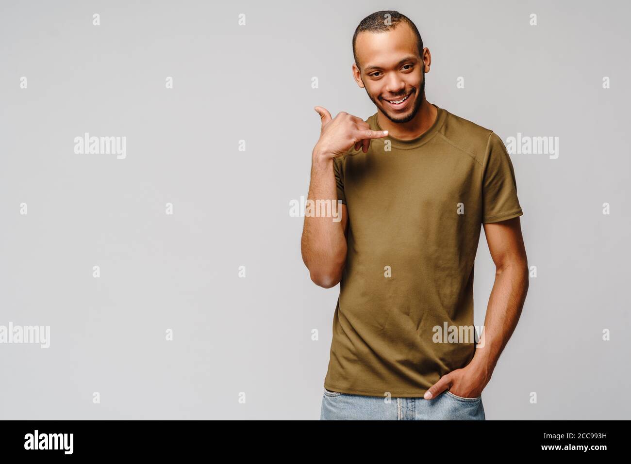Handsome young African American man showing a call me sign and smiling ...