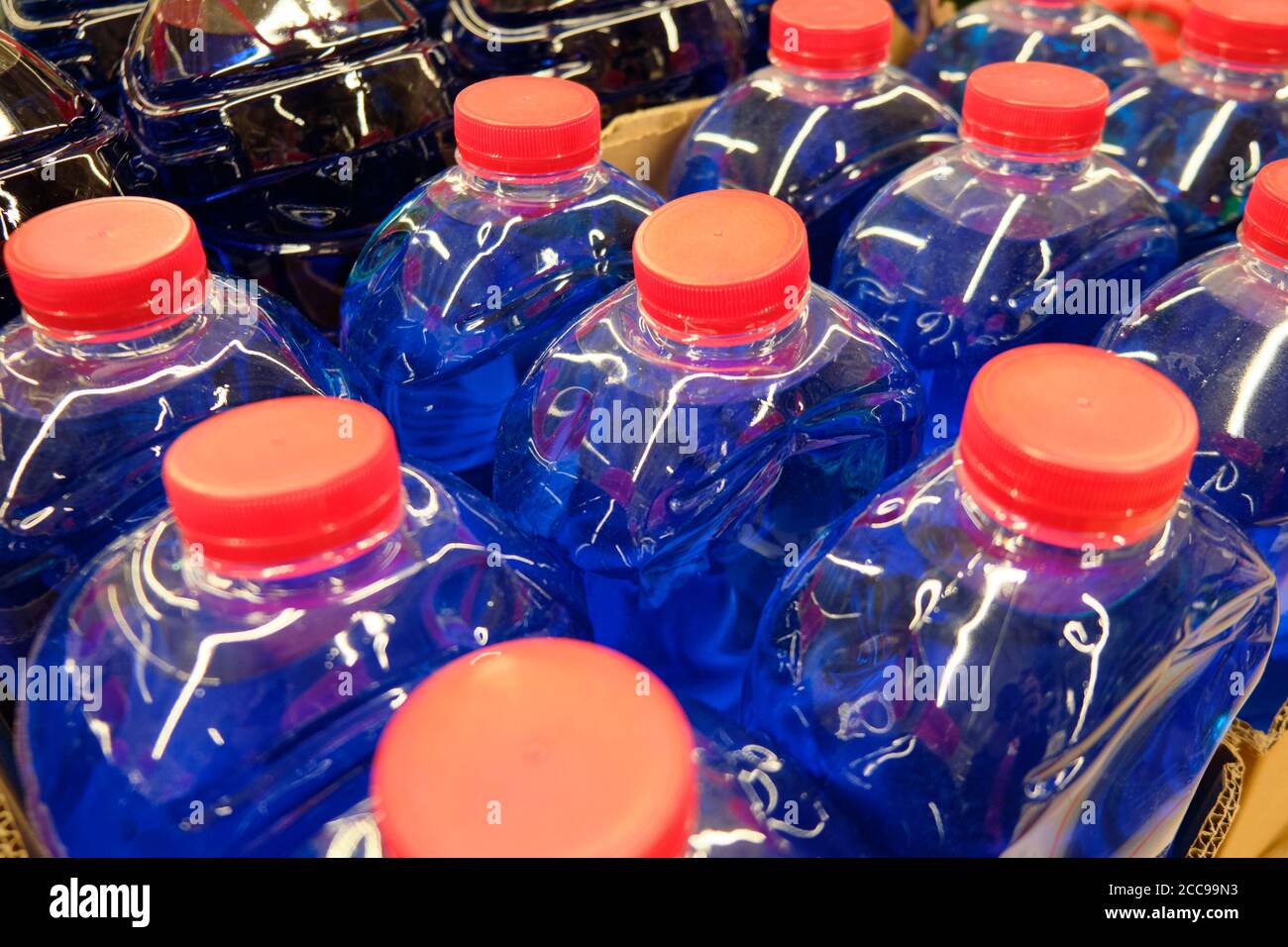 Dark blue fluid in the plastic bottles with red caps Stock Photo - Alamy