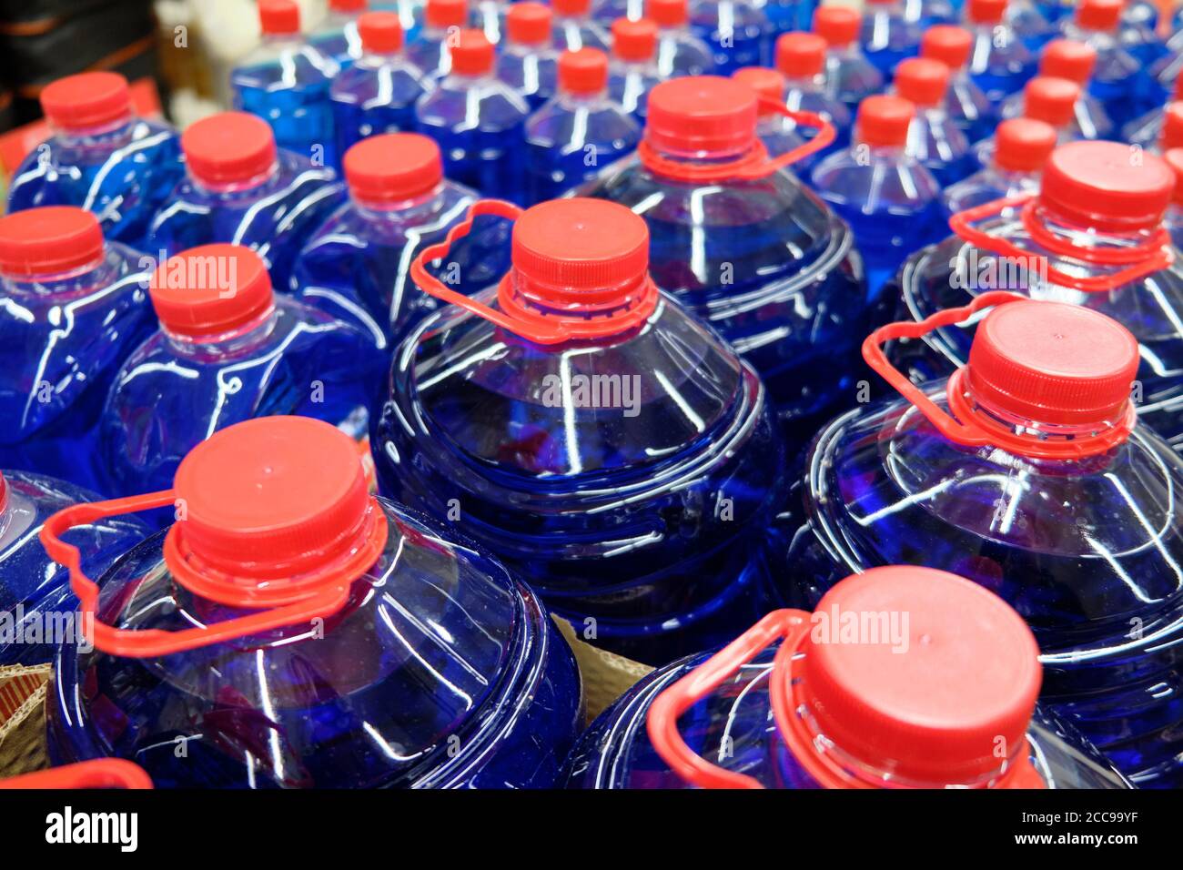 Dark blue fluid in the plastic bottles with red caps Stock Photo - Alamy