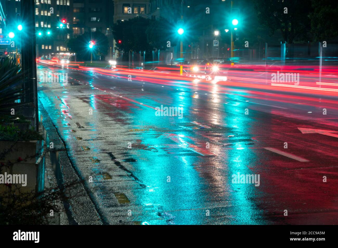 Reflection of traffic signals and moving traffic in wet street ...