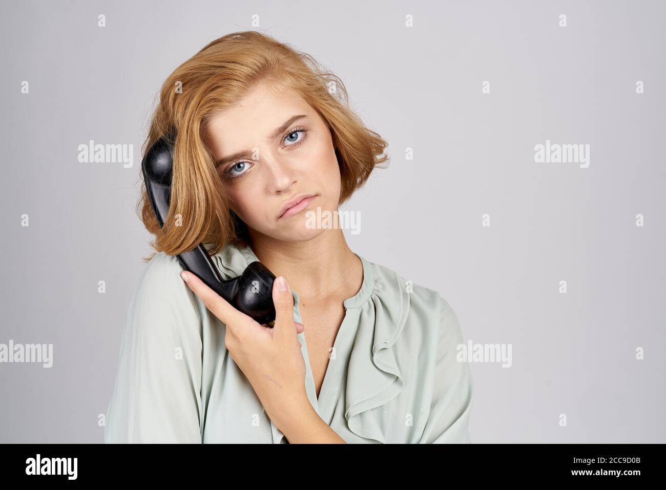 beautiful woman with retro phone in hand sad face shirt model light ...