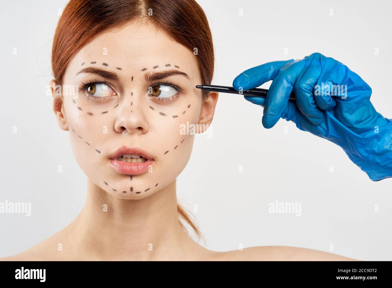 A woman in blue gloves holds a syringe in her hands and points botox ...