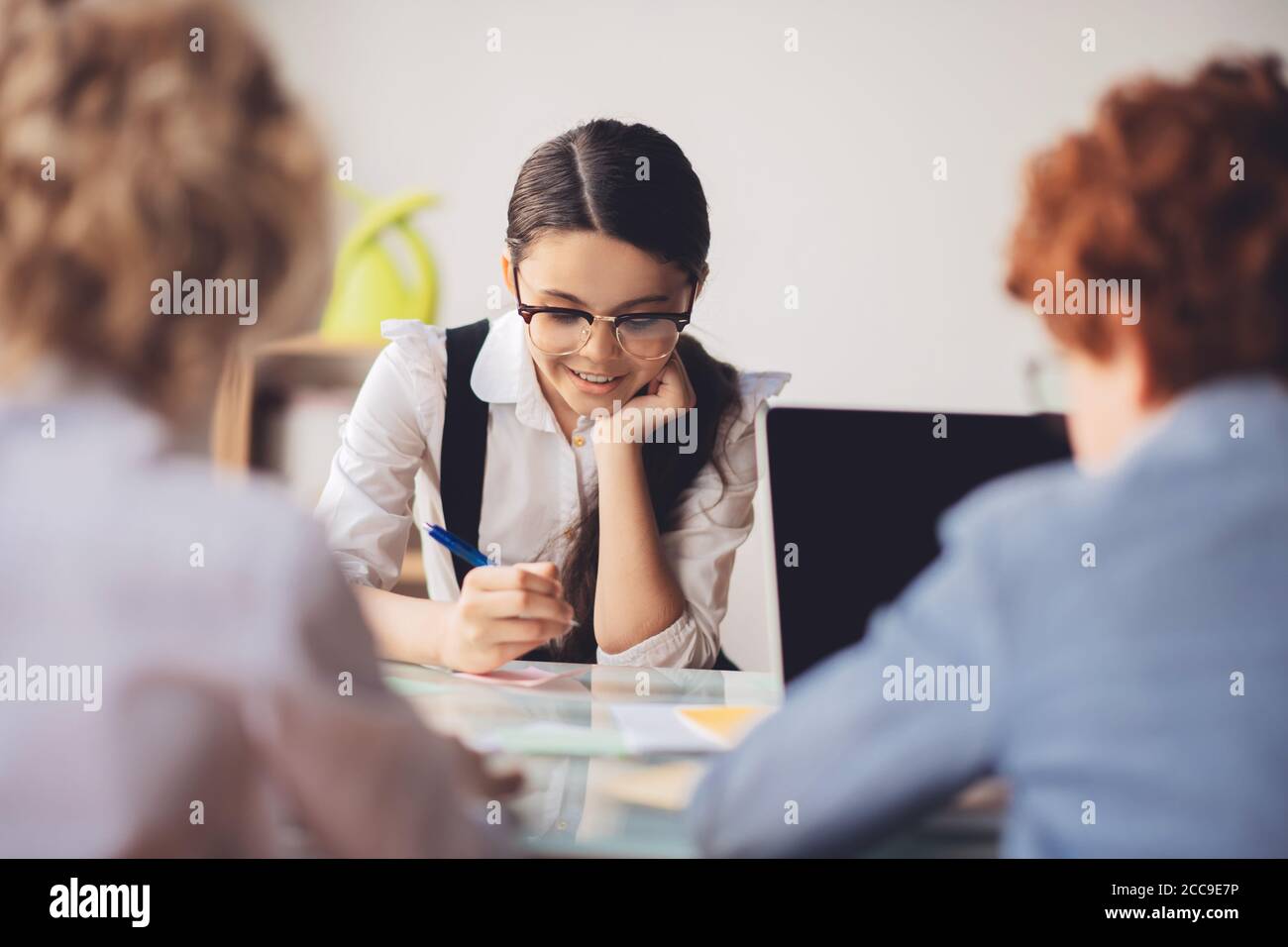 Dark-haired pretty girl studying with her classmates Stock Photo - Alamy