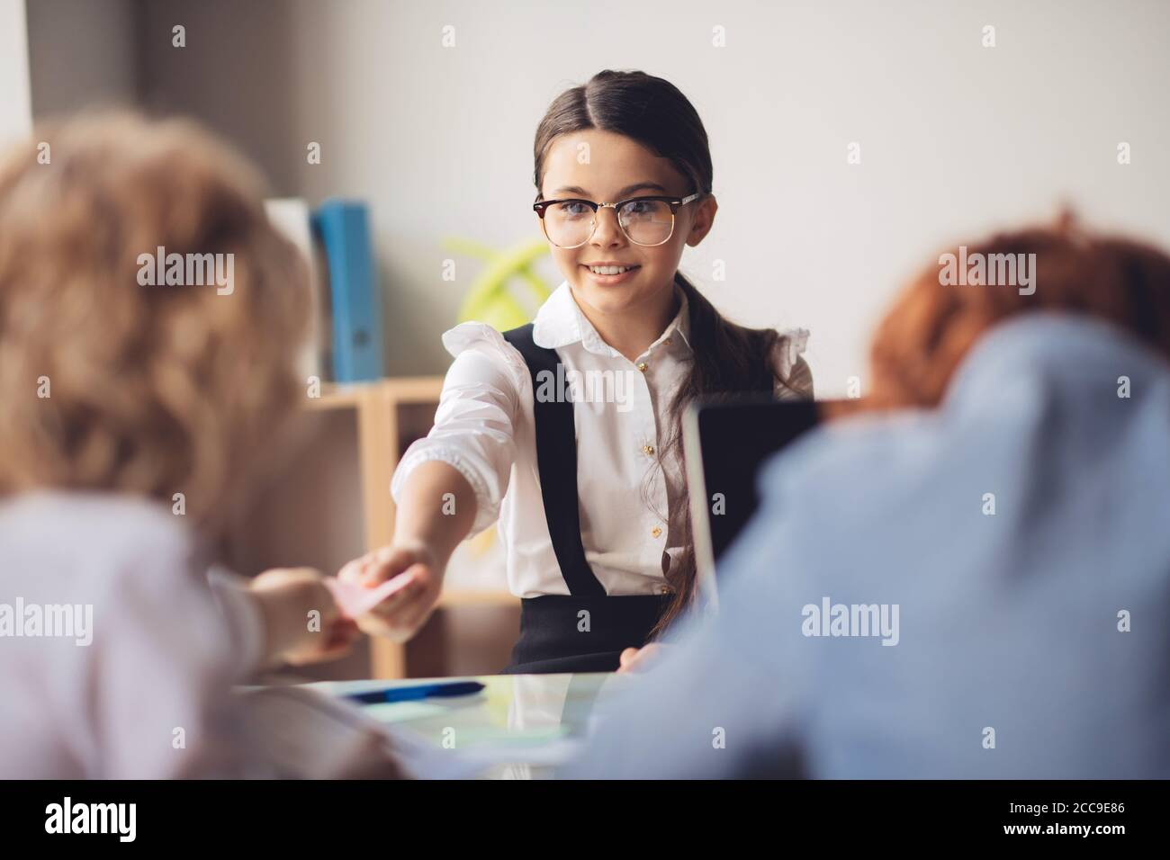 Dark-haired girl explaining lesson to her classmates Stock Photo - Alamy