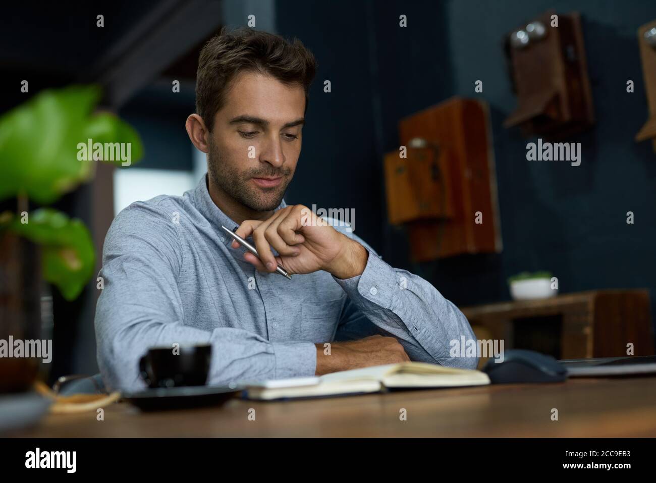 Young businessman going over notes while working at his desk Stock ...