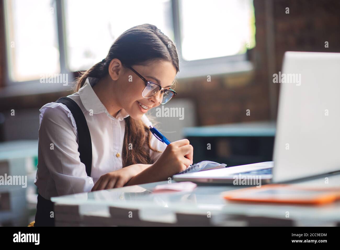 Dark-haired cute girl studying and looking pleased Stock Photo - Alamy