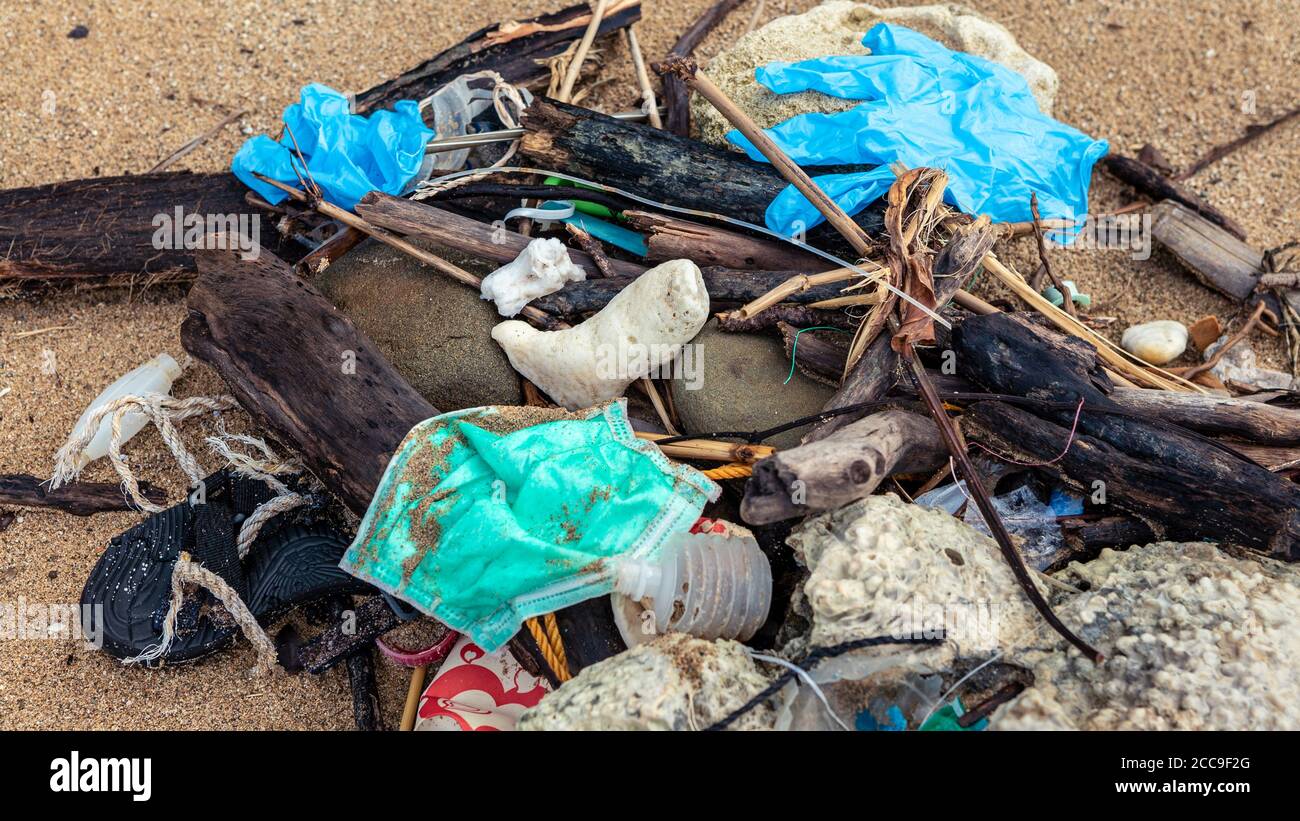 Medical waste, masks and plastic gloves garbage trash on sea shore ...