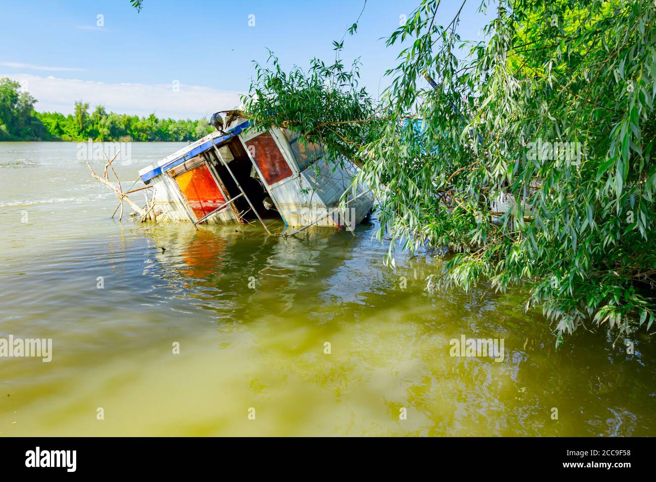 Wrecked small fishing boat is partially flooded, standing on the coast ...