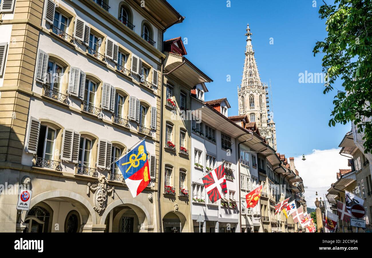 Scenic view of old buildings with city flags and Bern Minster cathedral ...