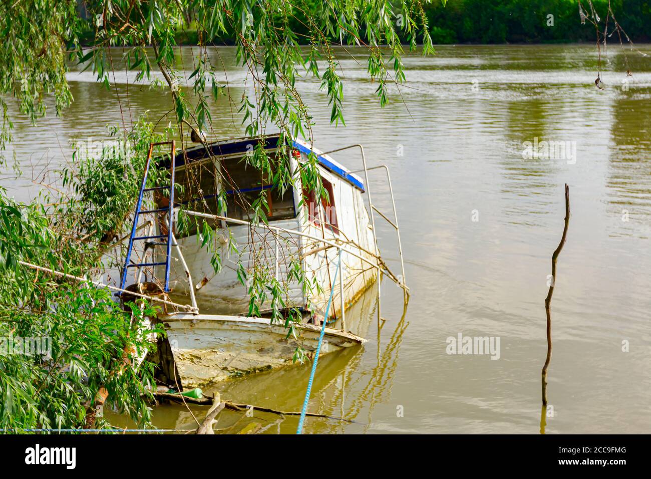 Wrecked small fishing boat is partially flooded, standing on the coast ...
