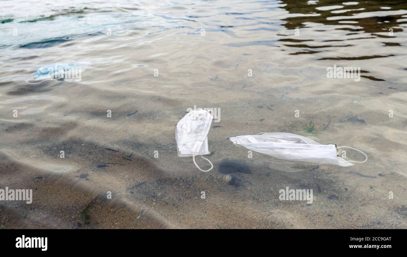 Waste during COVID-19. Discarded to ocean coronavirus single-use face ...