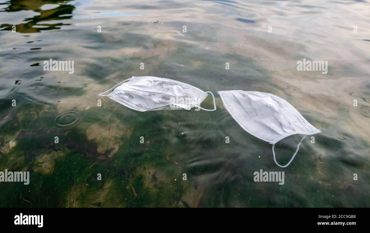 Waste during COVID-19. Discarded to ocean coronavirus single-use face ...