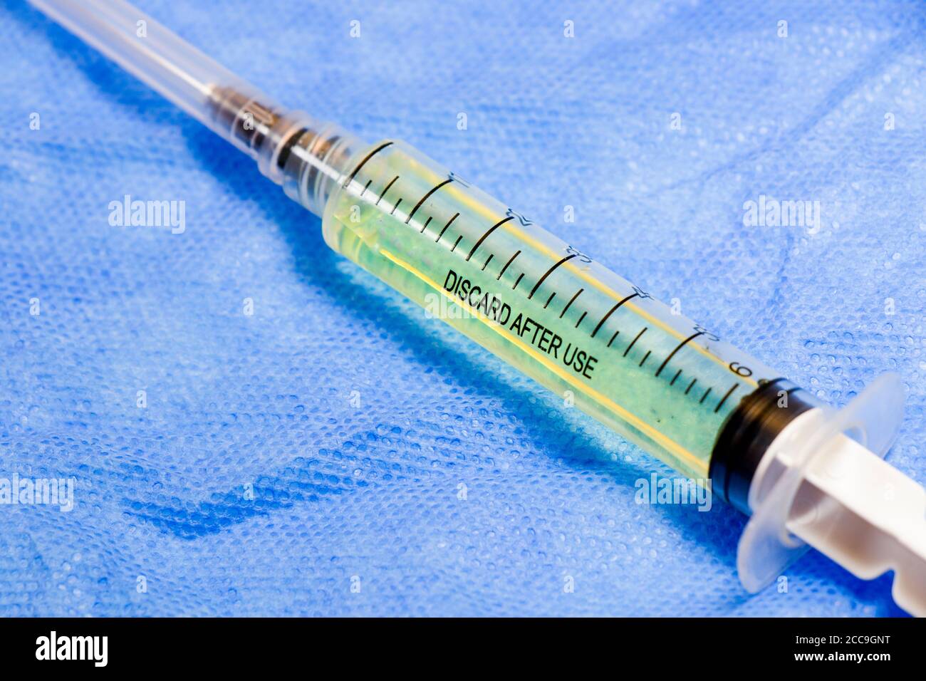 Medical needle on the sterile table with liquid vaccine, yellow vaccine ...