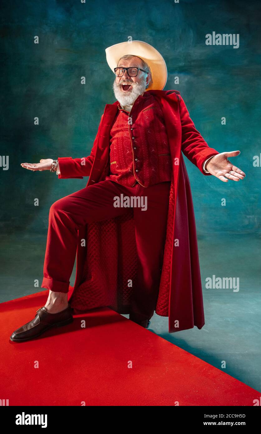 Performing. Modern stylish Santa Claus in red fashionable suit and ...
