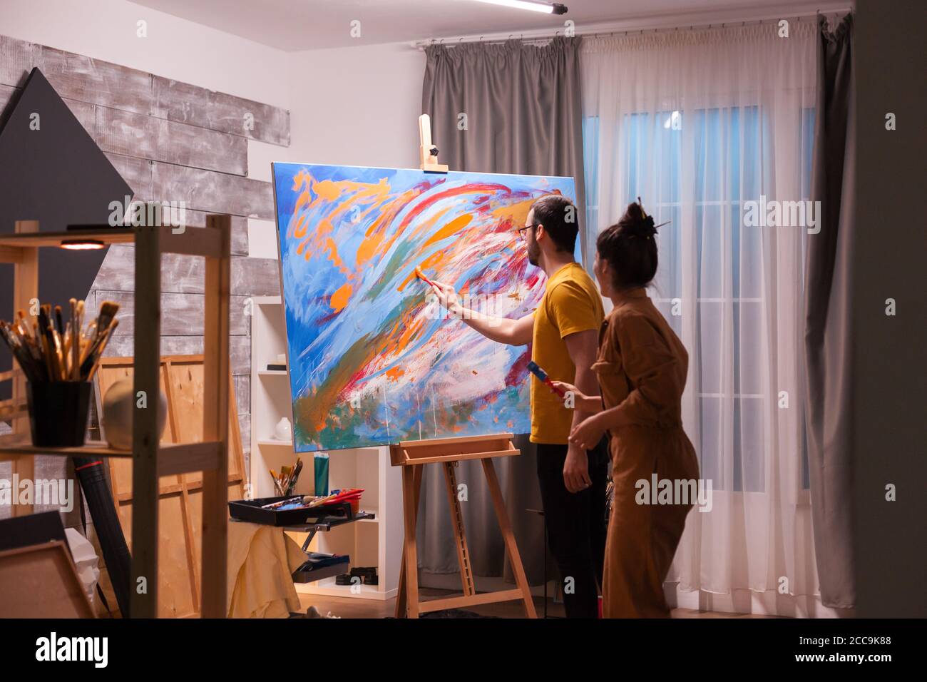 Couple working together on masterpiece painting on art workshop. Modern ...